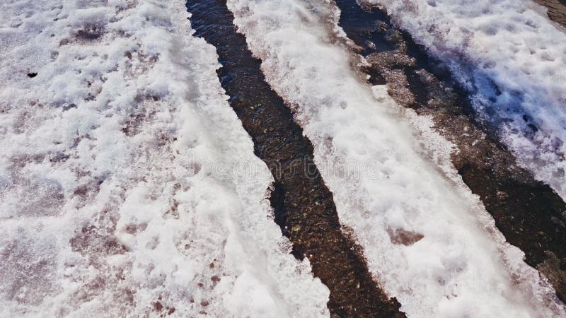 Stream with Meltwater Runs Down Road from Wet Snow Stock Footage ...