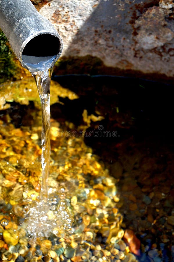A Stream of Pure Water Flows Out of the Pipe and the Bright Sun Shines ...