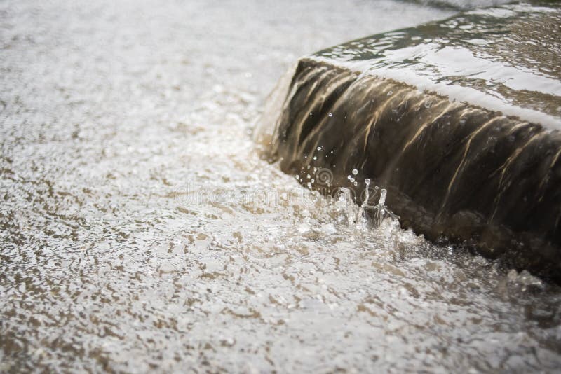 The Stream of Water Flows Down from the Sidewalk. Stock Image - Image ...