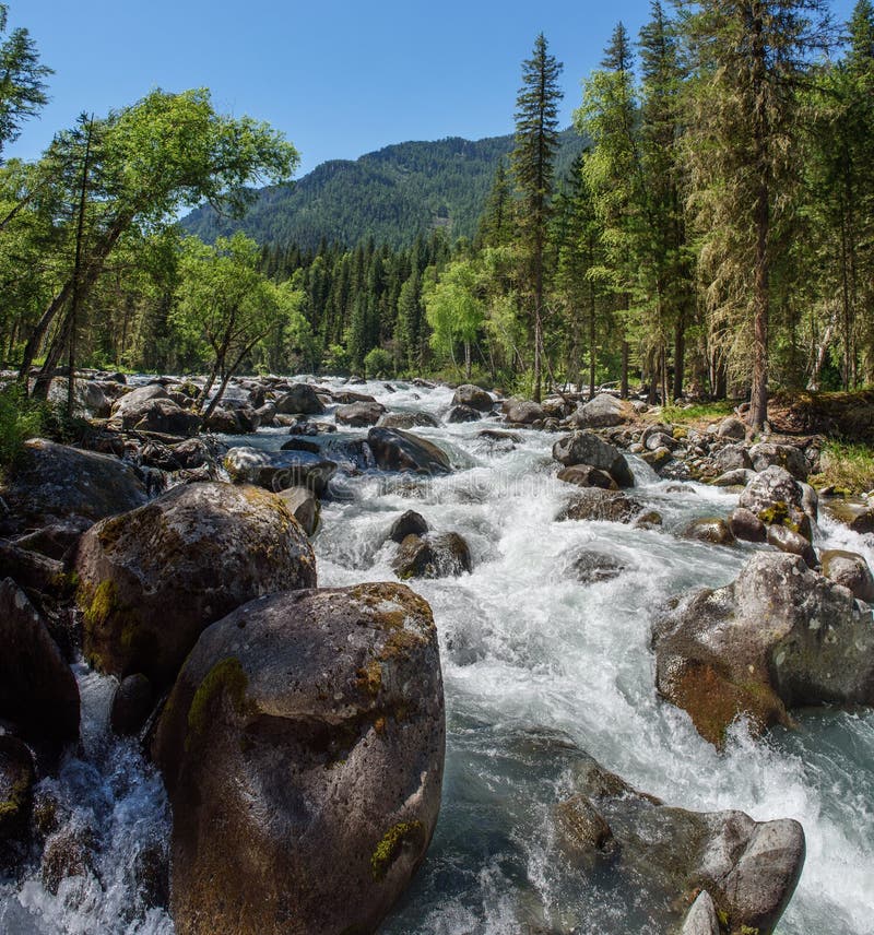 A Stream of Water Flows through a Large Rock in a Mountain River. Stock ...