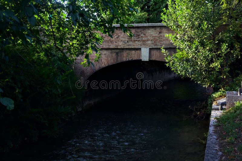 Stream of Water in the Shade with a Brick Bridge Stock Photo - Image of ...