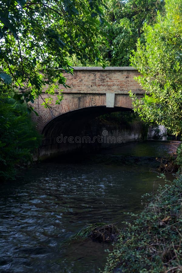 Stream of Water in the Shade with a Brick Bridge Stock Photo - Image of ...