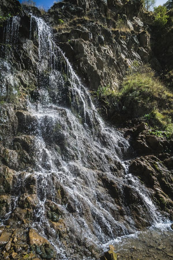 The Streams of a Cold Mountain Waterfall Cascade Down the Rocks of the ...