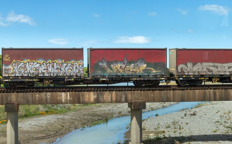 Graffiti on Containers on a Cargo Train Over a Blue Background ...