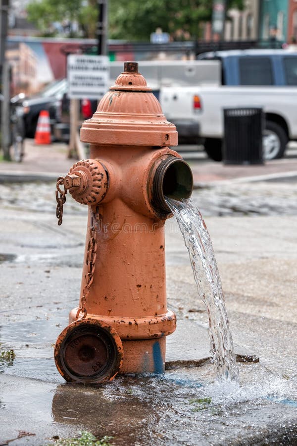 Street Orange Hydrant Spreading Water on the Street Stock Image - Image ...