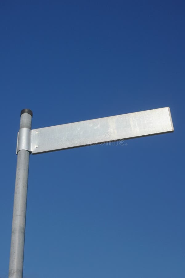 A Street Sign is Standing on a Pole in Front of a Blue Sky Stock Image ...
