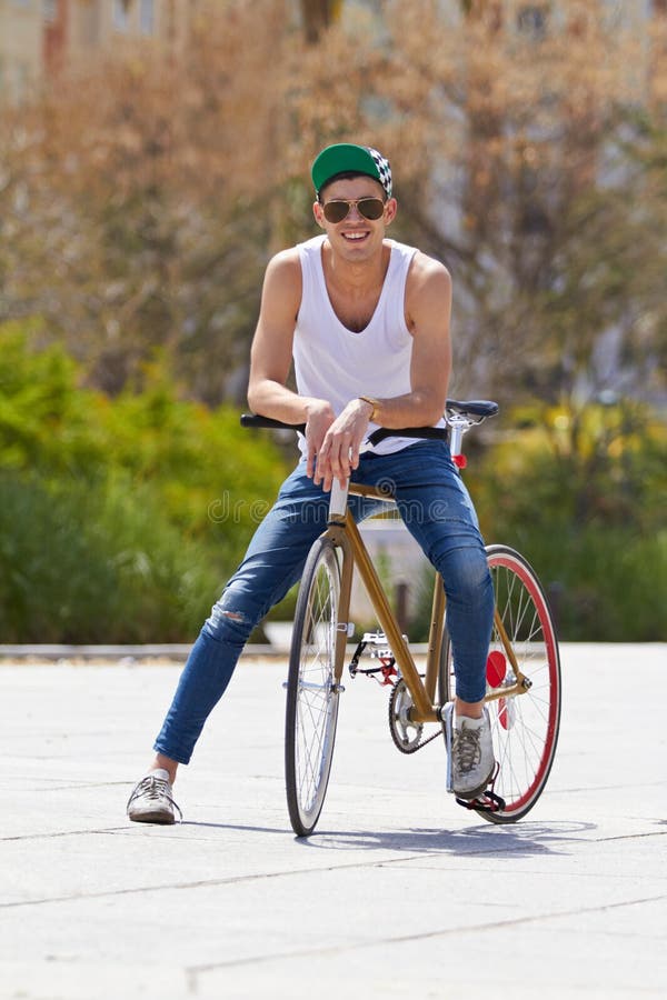 Street Style on Wheels. a Handsome Young Man Riding His Bicycle ...