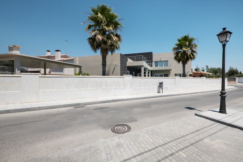 A Street in an Urbanization with a Curved Zebra Crossing and Palm Trees ...