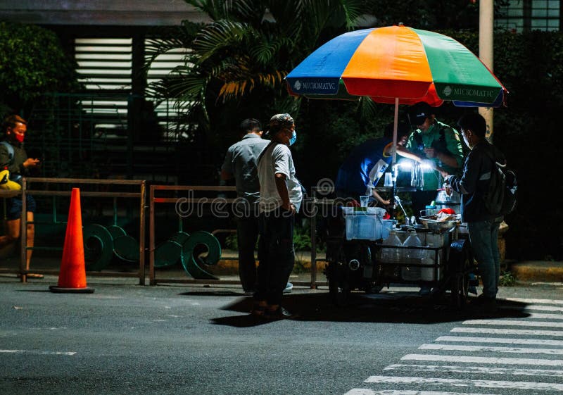 Street Vendor on an Empty Street with People Gathered Around it at ...