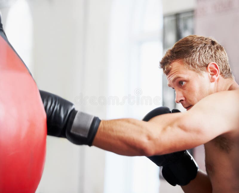 Strength and Focus. a Young Boxer Practicing with a Punching Ball ...