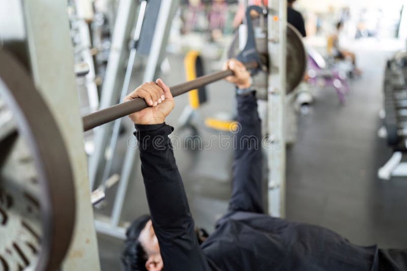 Strength Training. Man Lifting Weights on a Bench Press in the Gym ...