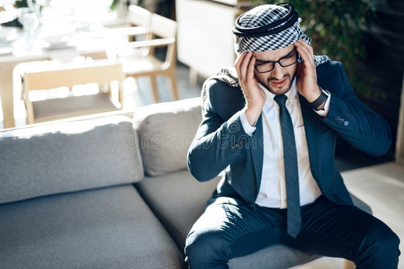 Stressed Arab Businessman on Couch at Hotel Room. Stock Image - Image ...