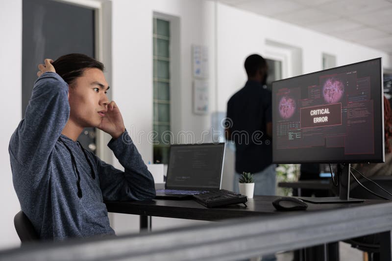 Stressed Asian Web Developer Having Security Breach Alert On Computer