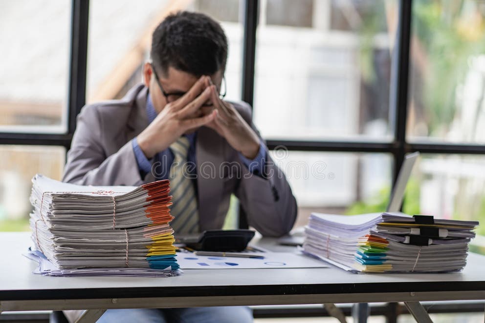 Stressed Businessman with Stacked Files on Table in Office Stock Image ...