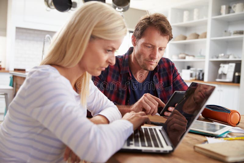 Stressed Couple Sitting in Their Kitchen Using Computers Stock Image ...