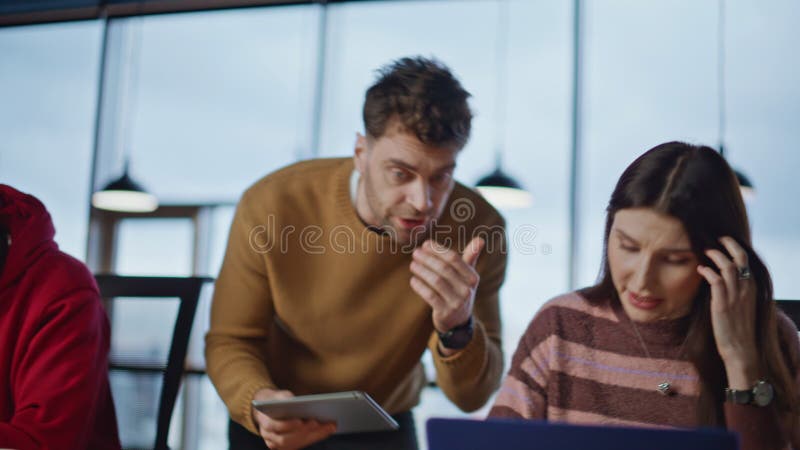 Stressed Executive Explaining Task To Office Team Working at Laptops ...