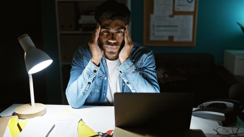 Stressed Hispanic Man with Beard in Office Late at Night, Hands on Head ...