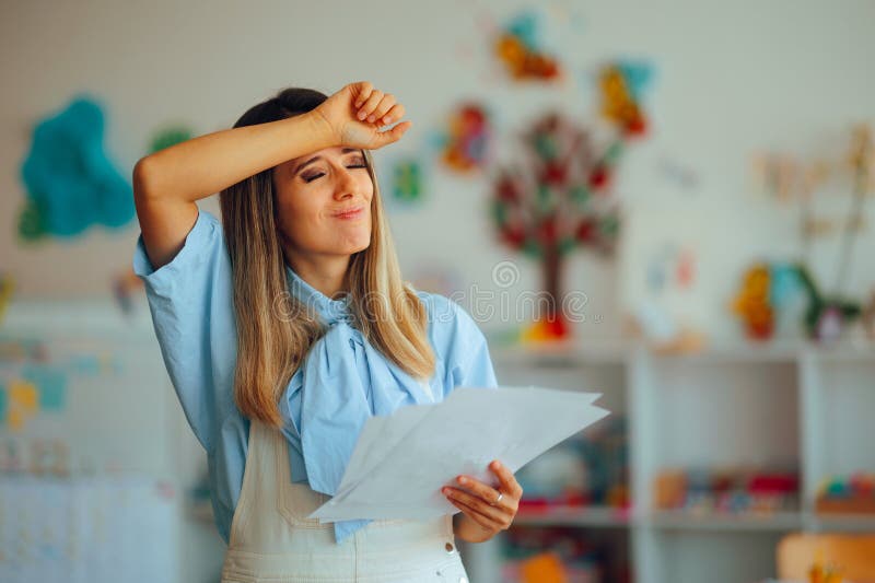 Stressed Kindergarten Teacher Holding Activity Sheets from Students ...