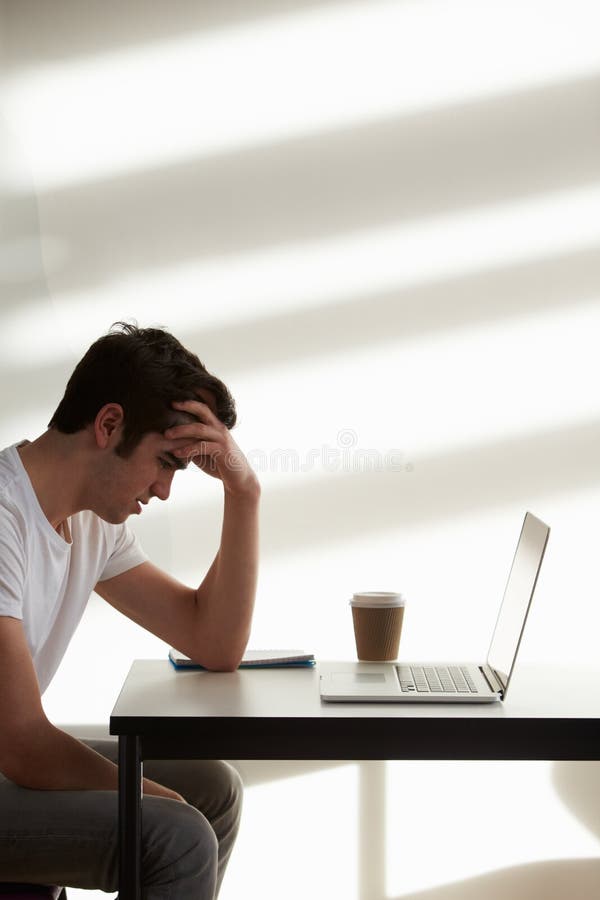 Stressed Male College Student Using Computer in Classroom Stock Photo ...