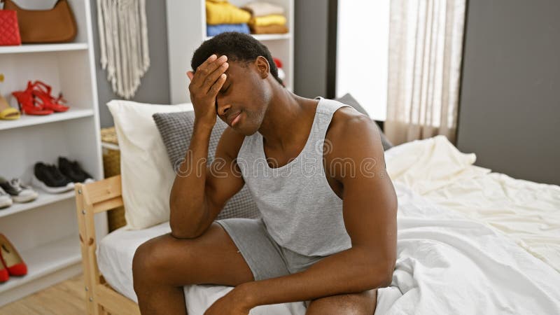 Stressed Man Sitting on Bed in a Bedroom, Looking Tired and Frustrated ...