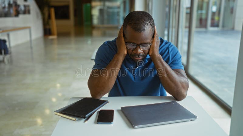 Stressed Man Sitting in Office with Hands on Head and Laptop, Phone ...