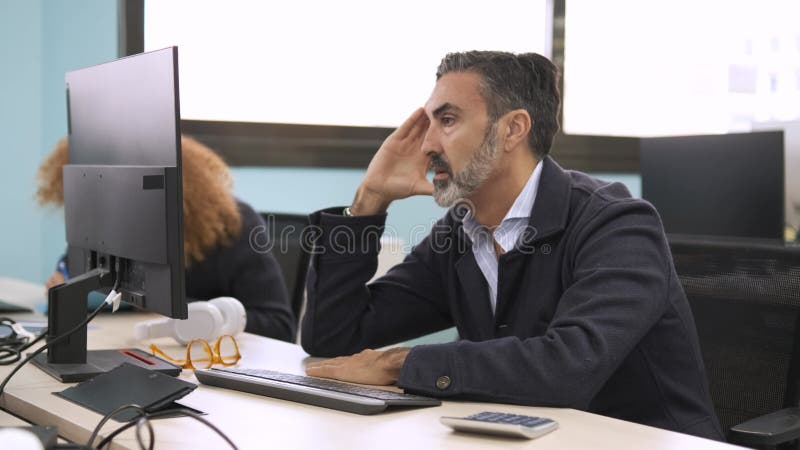 Stressed Businessman Using Computer at Desk and Sitting with Head in ...