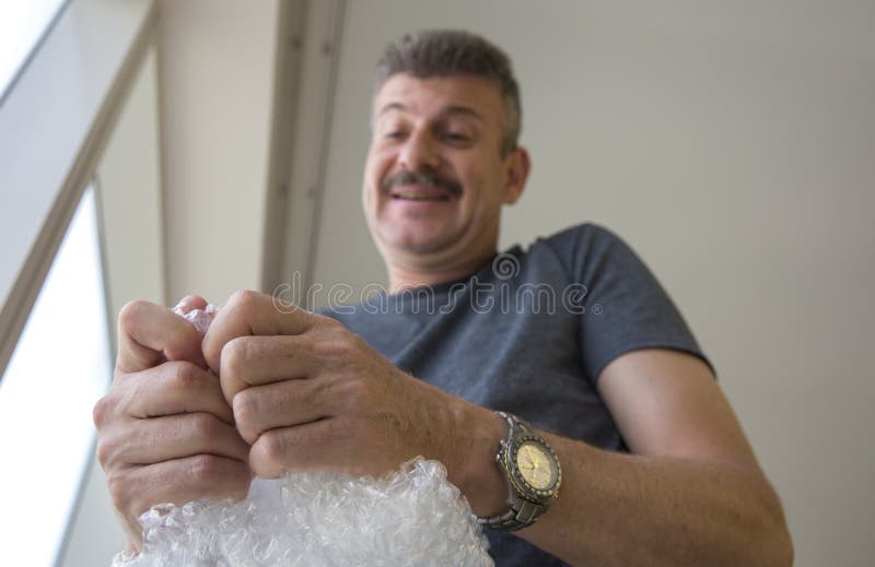 Middle Aged Man Popping Bubble Wrap Stock Image - Image of arab ...