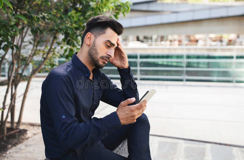 Stressed Middle Eastern Business Guy Using App on Phone Outside Stock ...