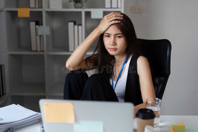 Stressed Office Worker at Desk with Laptop and Documents in Modern ...