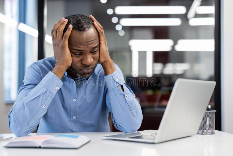 Stressed Office Worker Sitting at Desk with Laptop, Hands on Head in ...