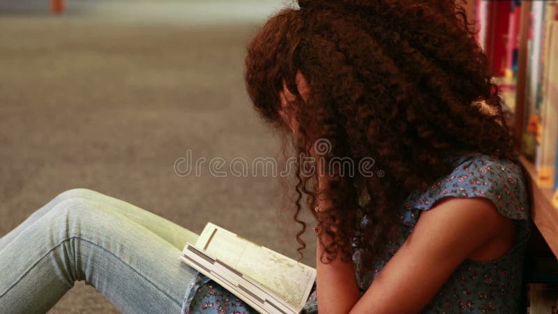 Stressed Student Studying and Taking Notes in the Library Surrounded by ...