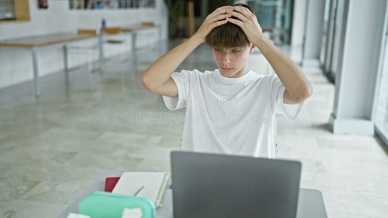 A Stressed Young Man Studying on Campus with Laptop, Notebook ...