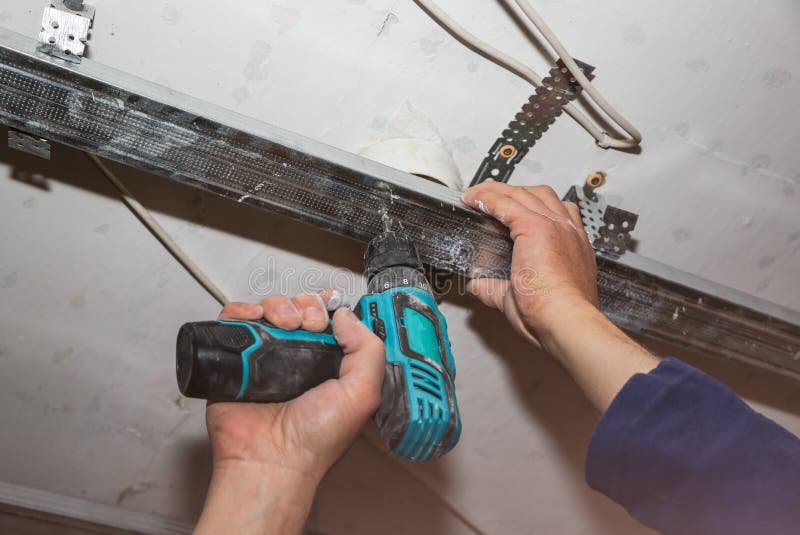 Stretch Ceiling Metal Constructions. Man in Using Electric Drill ...