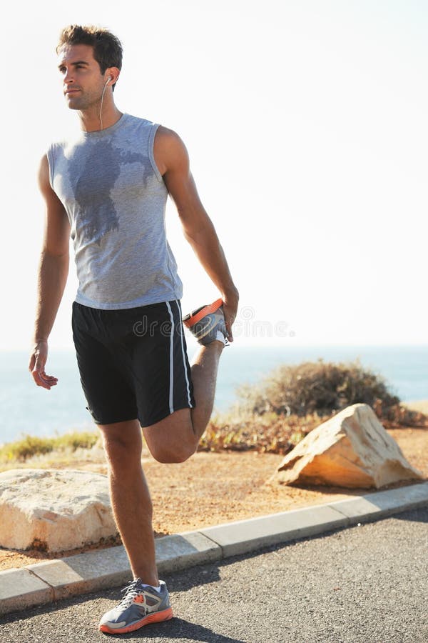 Stretching those Tired Muscles. Young Jogger Standing and Stretching ...