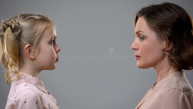 Strict Mother Looking Scared Daughter On Grey Background Discipline