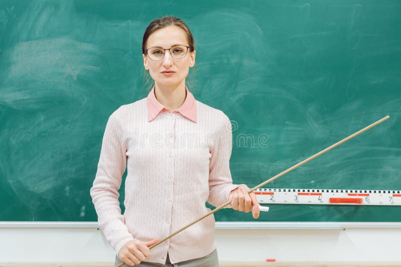Strict Teacher Standing in Front of Blackboard in Class Stock Photo ...