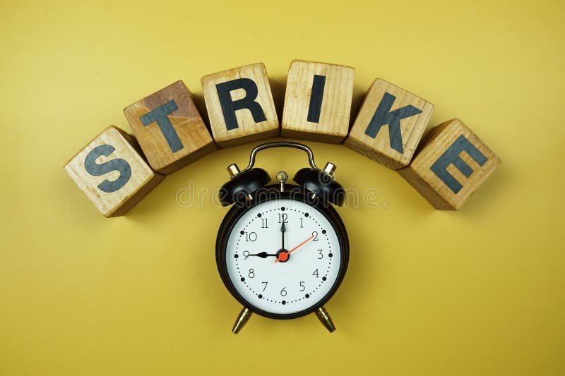 Strike Word and Alarm Clock Top View on Yellow Background Stock Image ...