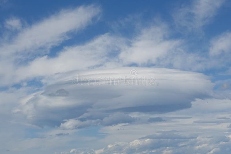 A Striking, Circular Cloud Formation is Visible Against a Bright Blue ...