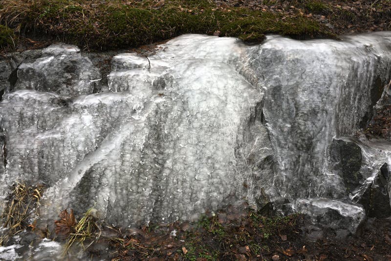 A Striking Close-up of Ice Formations Cascading Over Rugged Rocks ...
