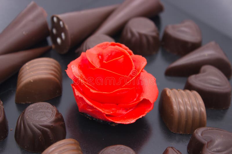 Close-up of Red Rose with Assorted Chocolates on Black Plate Stock ...