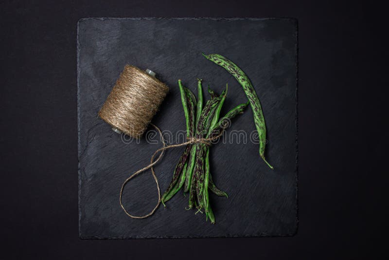 Green String Beans Tied in a Bunch Hanging on a Black Background Stock ...