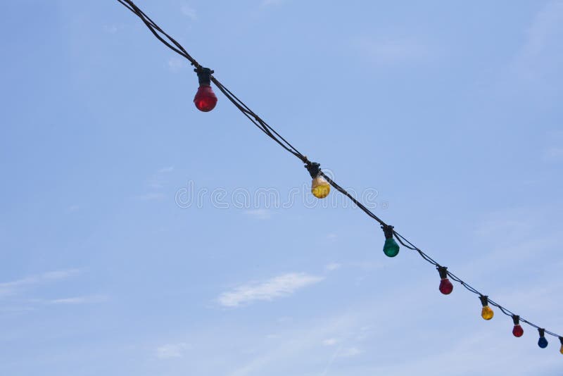 String of Coloured Lights Against Blue Sky in Coastal Town Stock Image ...