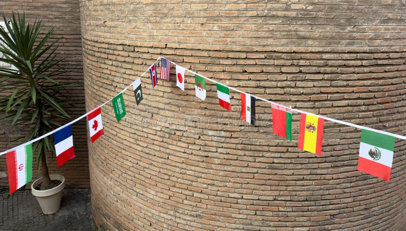 A String of Flags Hangs on a Brick Wall Stock Image - Image of colorful ...
