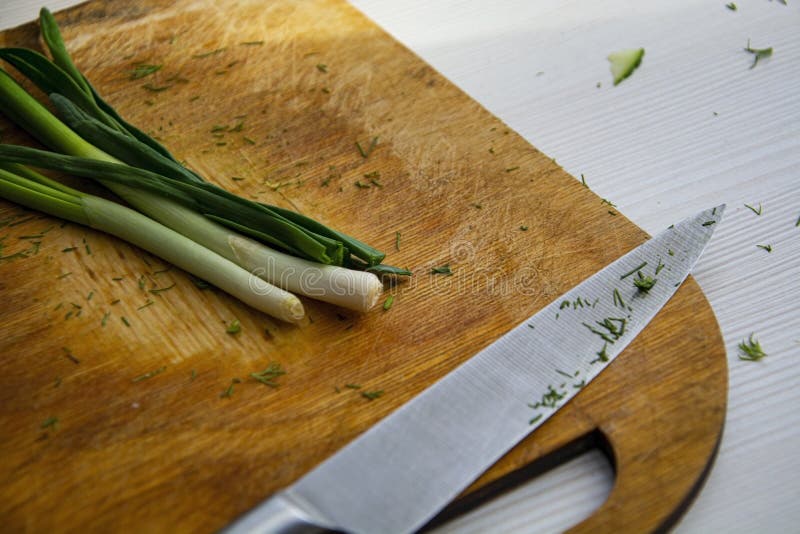 String Green Onions on a Chopping Board with a Kitchen Knife. Stock ...
