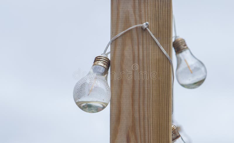 A String of LED Bulbs Hanging from a Wooden Post Stock Photo - Image of ...