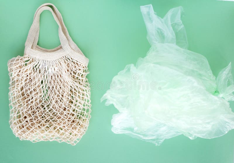 String Reusable Bag and a Pile of Plastic Bags on Green Background ...