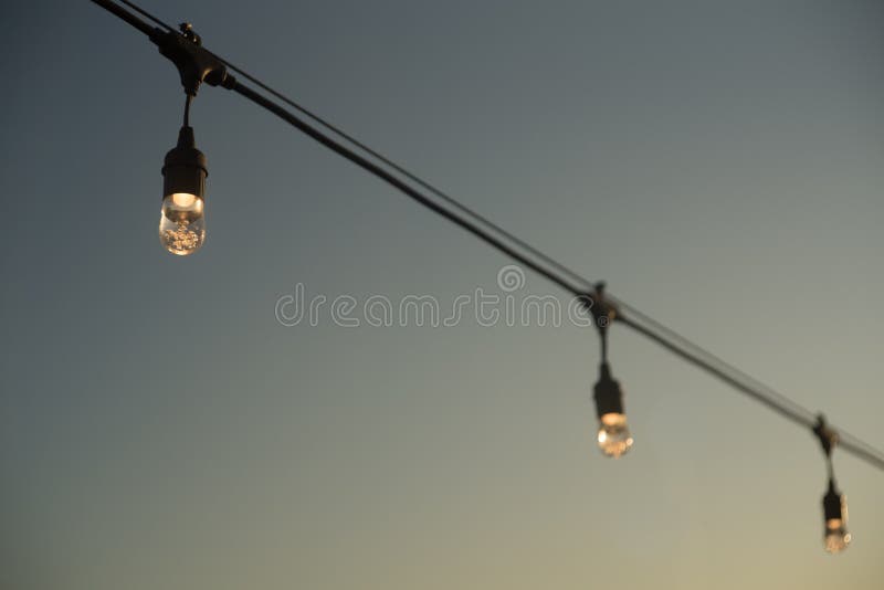 String of Three Bulb Lights in Front of the Sky Stock Photo - Image of ...
