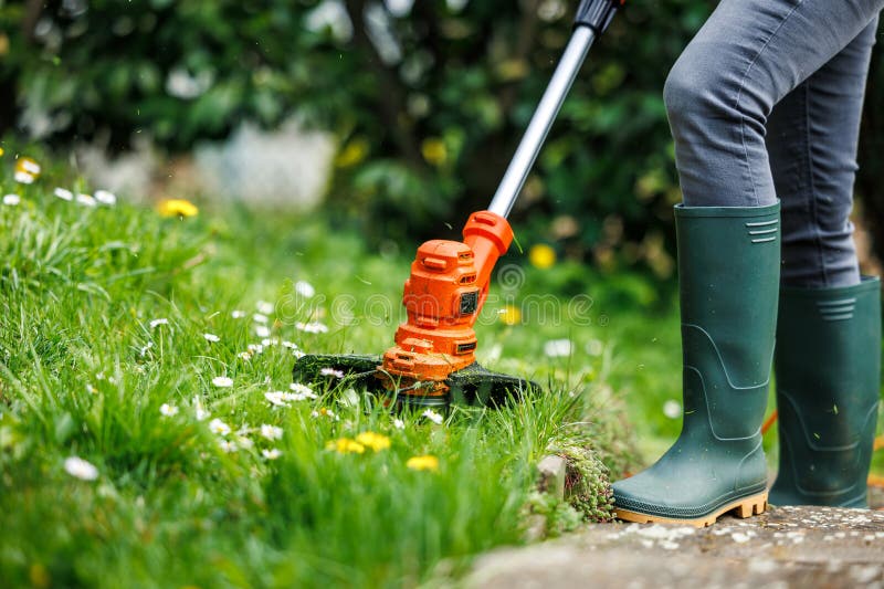 String Trimmer. Woman is Cutting Grass in Garden Stock Image - Image of ...