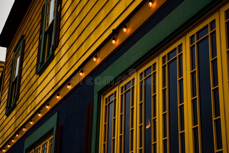 Illuminated Edison Light Bulbs on Wire Against Yellow Painted Building ...