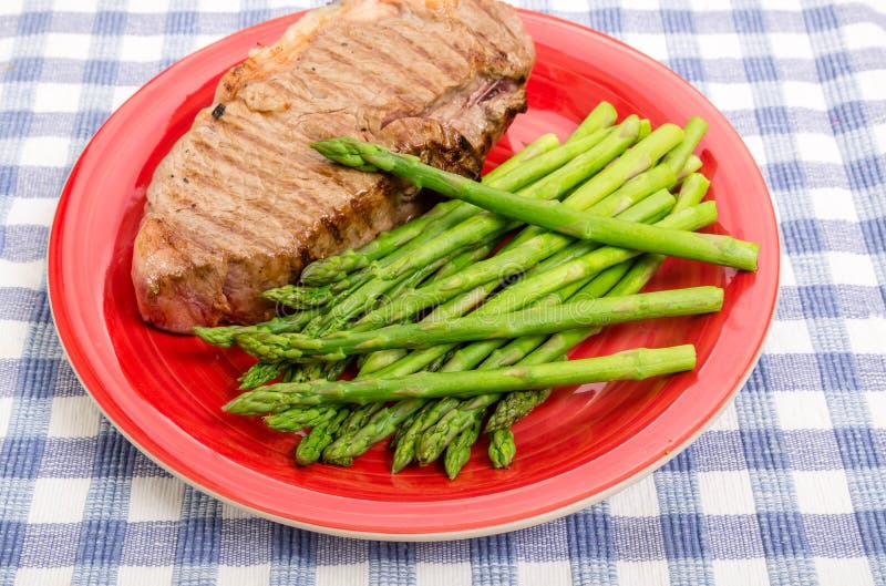 Strip Steak and Asparagus on Red Plate Stock Photo - Image of health ...